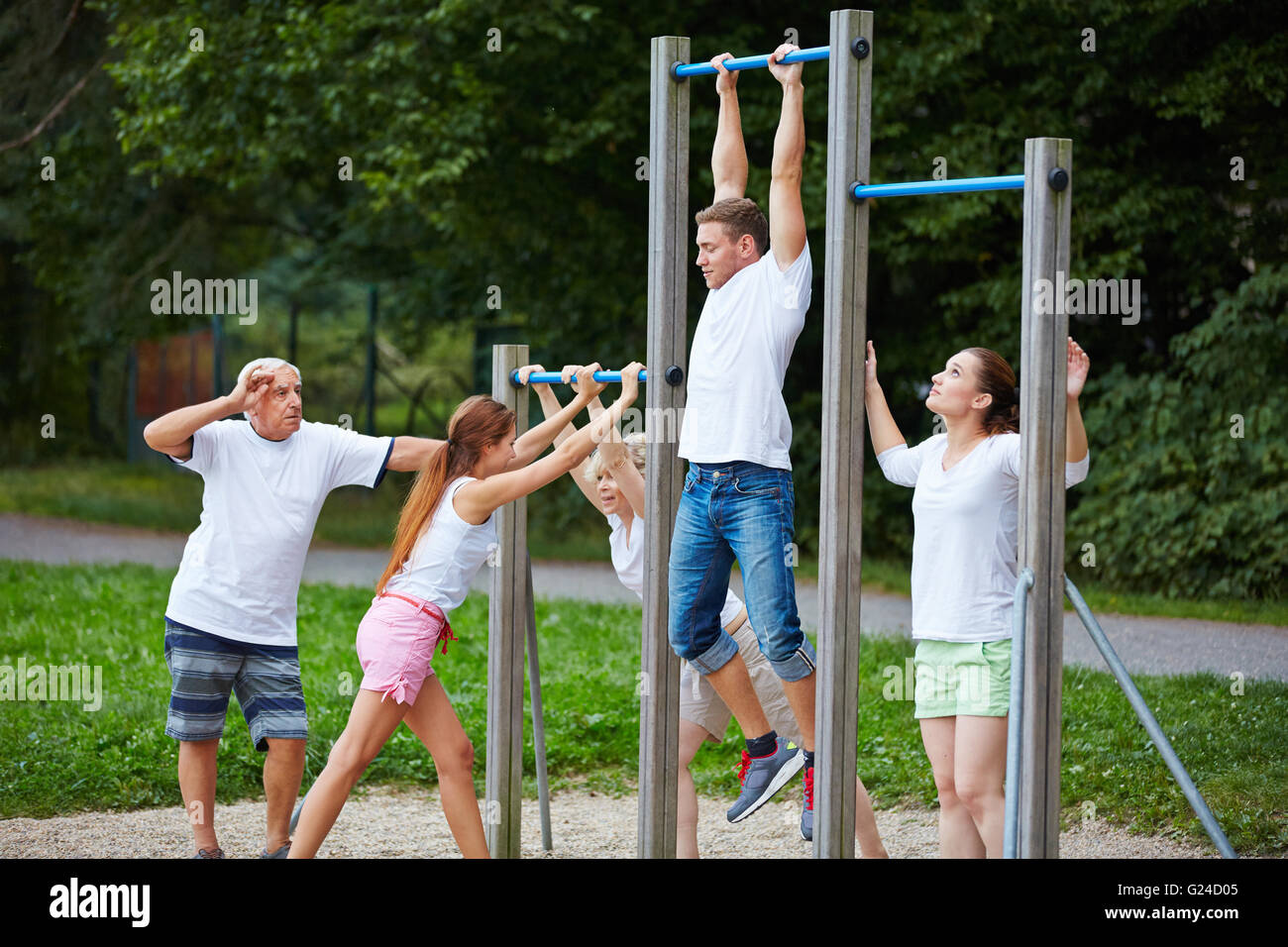 Group doing fitness training together in nature at horizontal bars ...