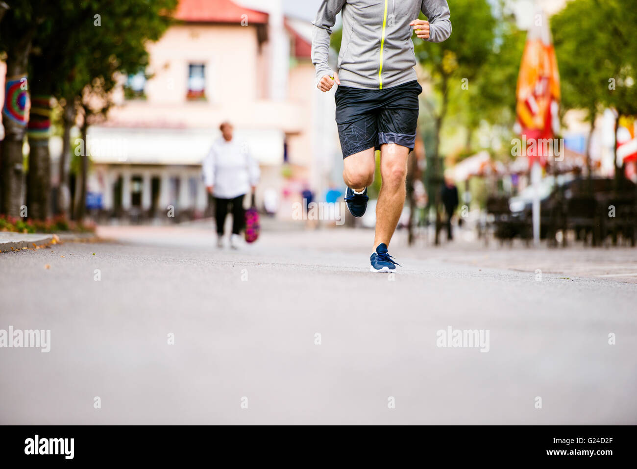 Unrecognizable young man running in town, main street Stock Photo - Alamy