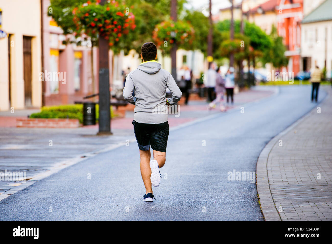 Young hipster man running in town, main street Stock Photo - Alamy