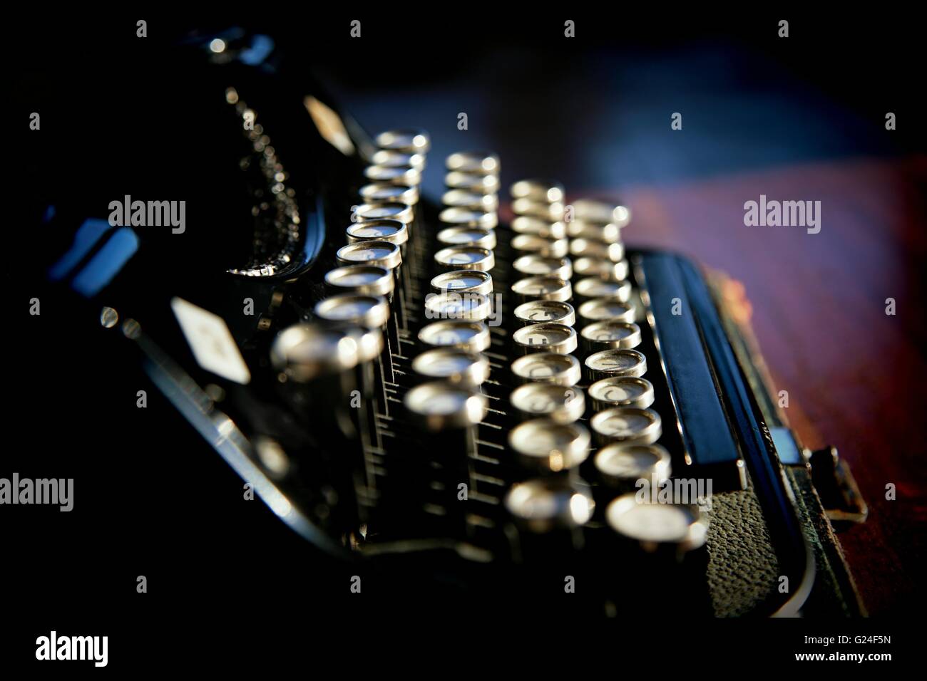 Old black typewriter on dark background with shiny keys, side view ...