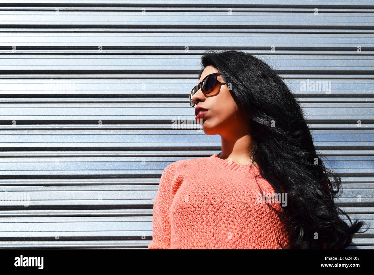 Young latin woman posing outdoors. Trendy and urban style. Model posing ...