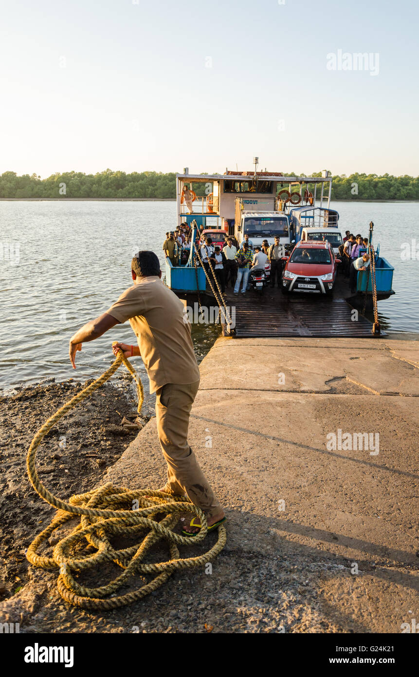 A ferry worker pulls the coir rope used to dock ferry boat as it ...