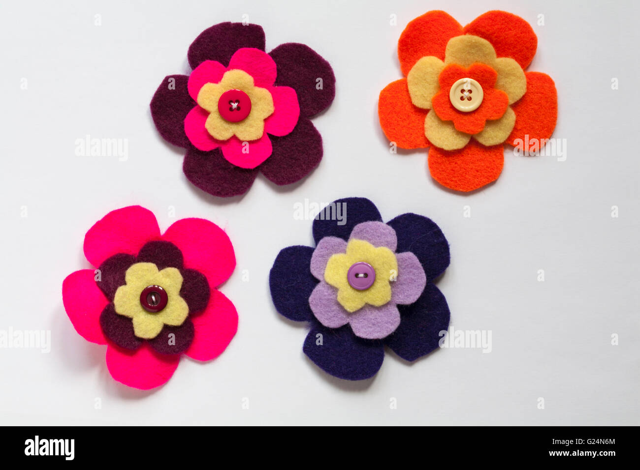 Handmade colourful badges made from felt and buttons isolated on white ...