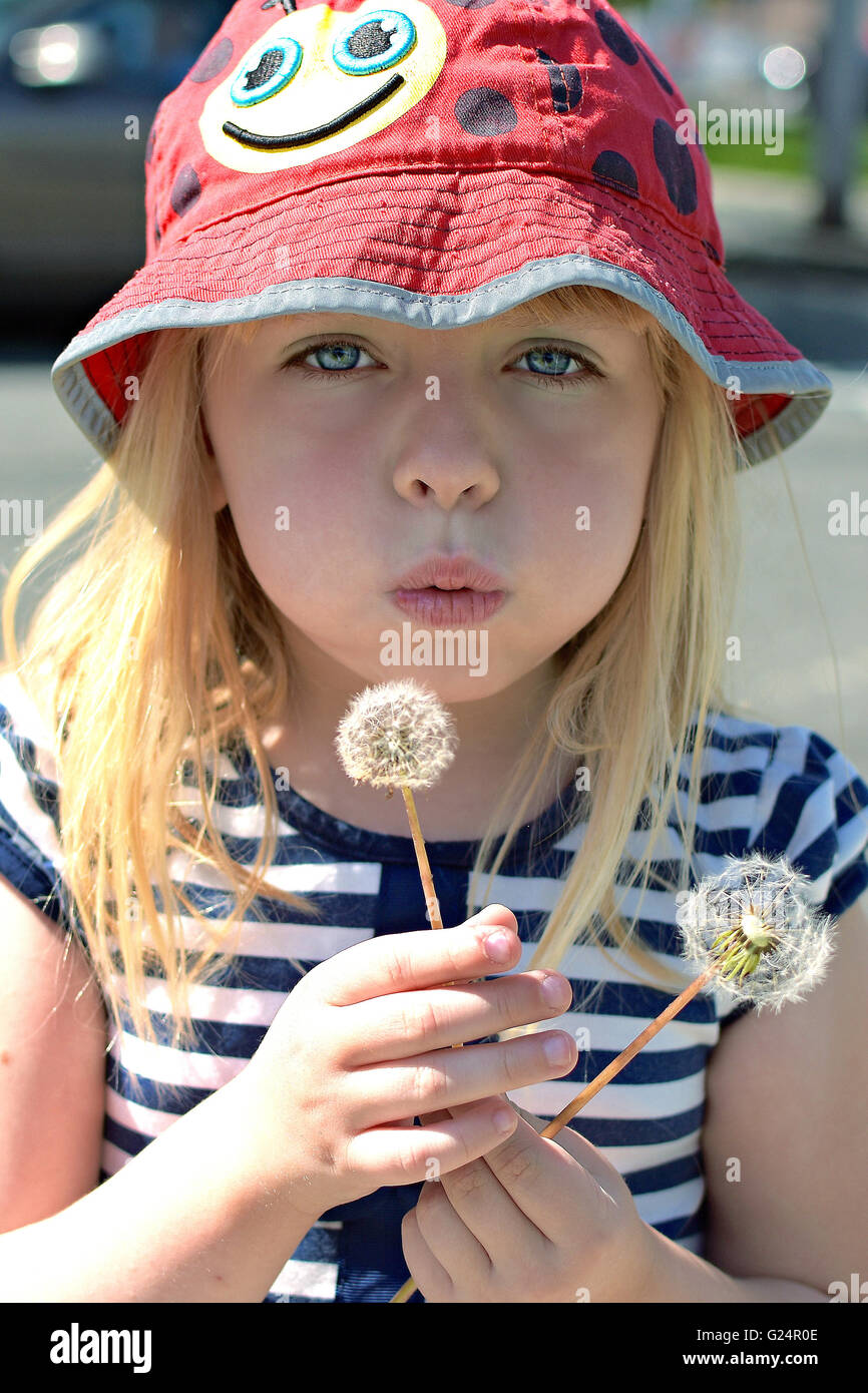 young girl blowing dandelion in springtime Stock Photo - Alamy