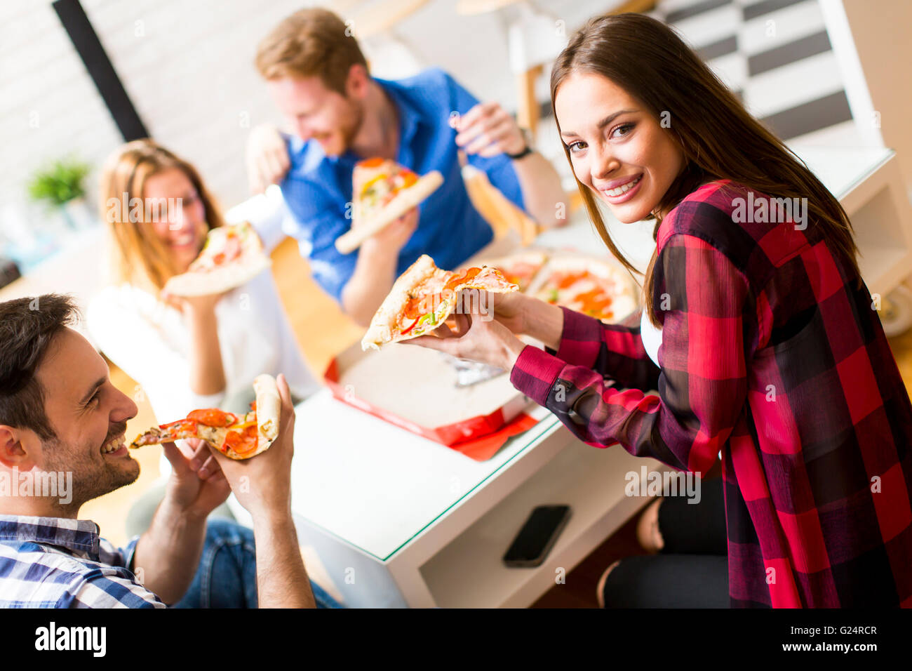 Group of friends eating pizza together at home Stock Photo - Alamy