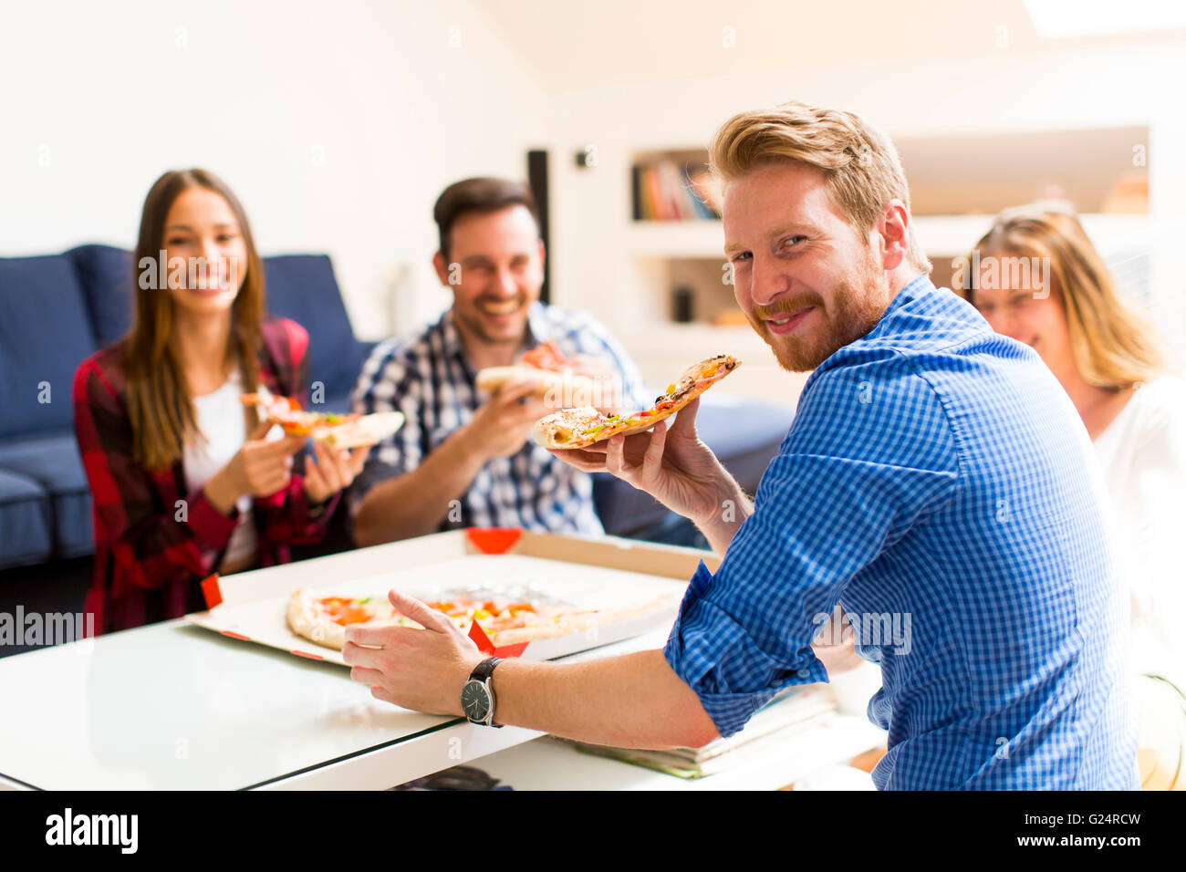 Group of friends eating pizza together at home Stock Photo - Alamy