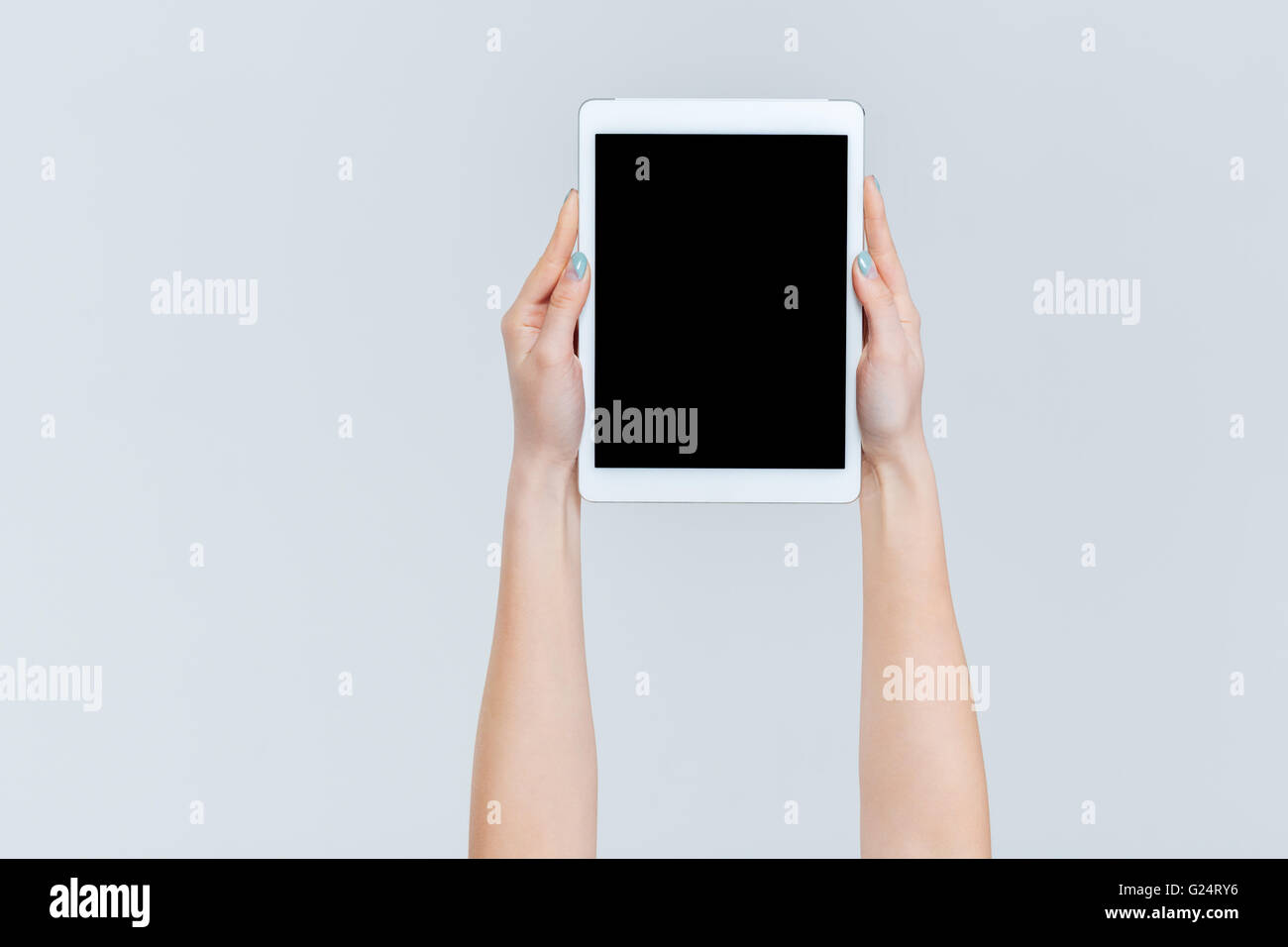 Female hands holding tablet computer with blank screen isolated on a ...