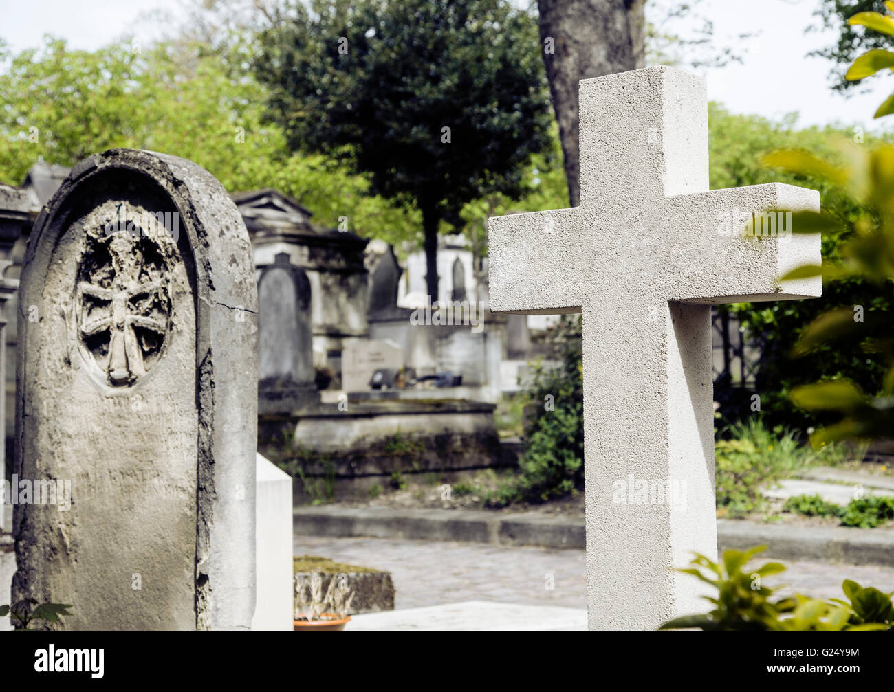 Tombstones in cemetery at dusk, gothic style crosses Stock Photo - Alamy