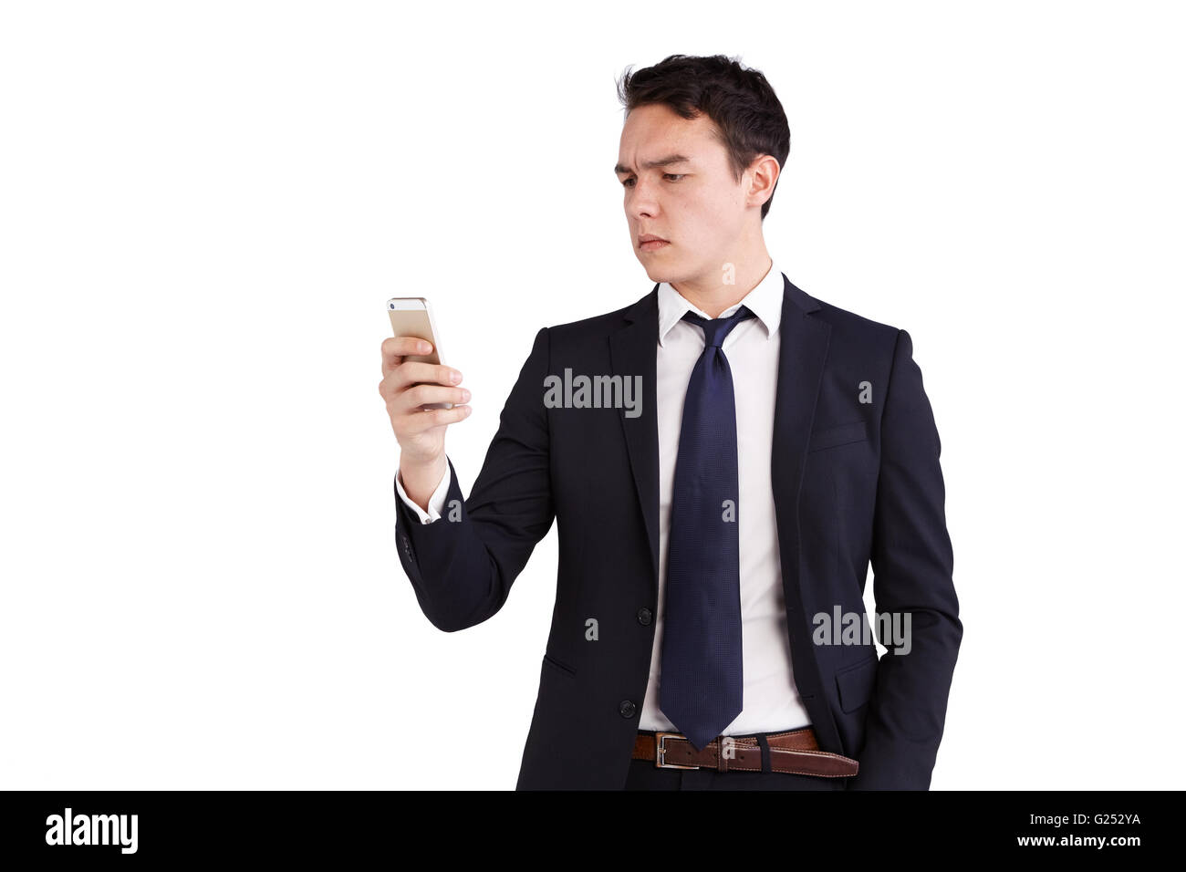 A young Caucasian business man is looking at his mobile phone. His ...