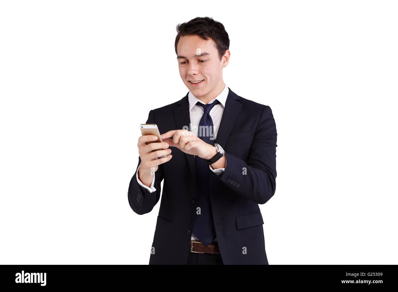 A young Caucasian business man is holding a mobile phone smiling. He is ...
