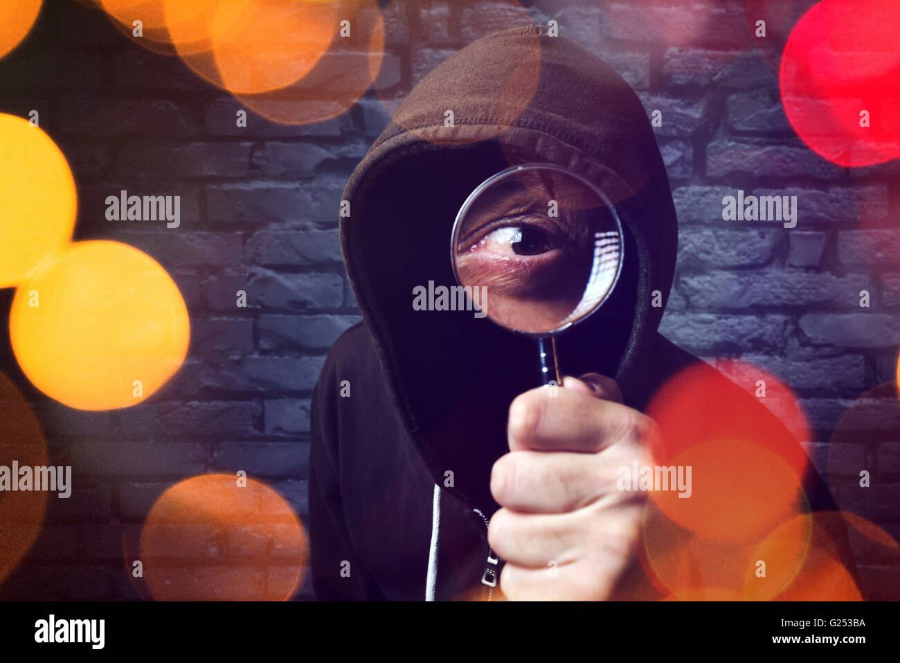 Hooded computer hacker with magnifying glass, internet hacker and ...
