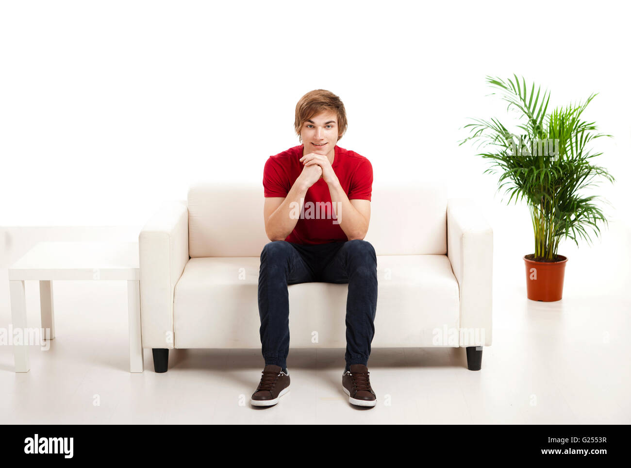 Handsome young man at home sitting on the couch Stock Photo - Alamy