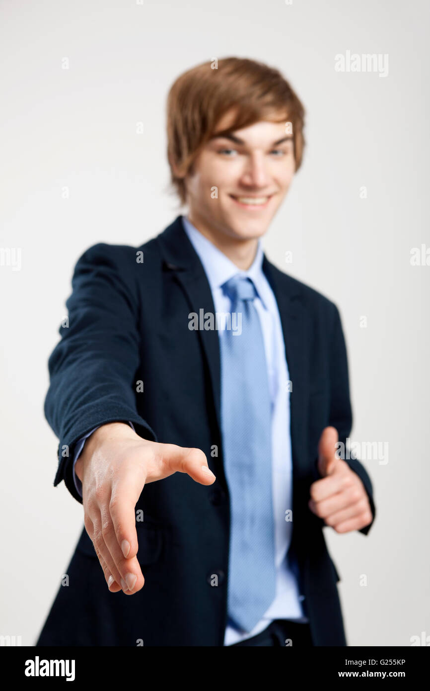 Young businessman giving a hand shake, over a gray background Stock ...
