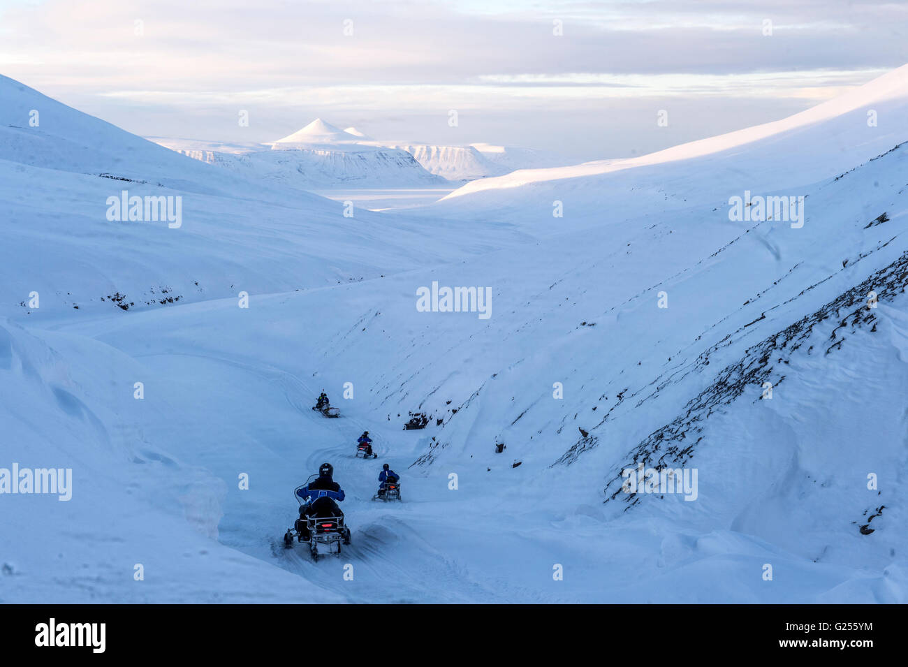 Snowmobiles with snow-capped mountains Longyearbyen, Svalbard ...