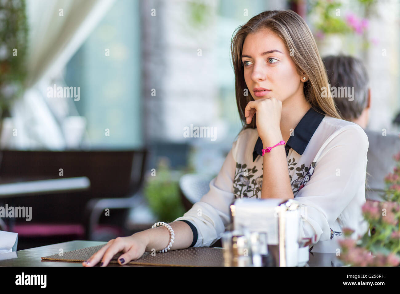 Young beautiful girl with long hair sitting in cafe. Fashion girl in ...