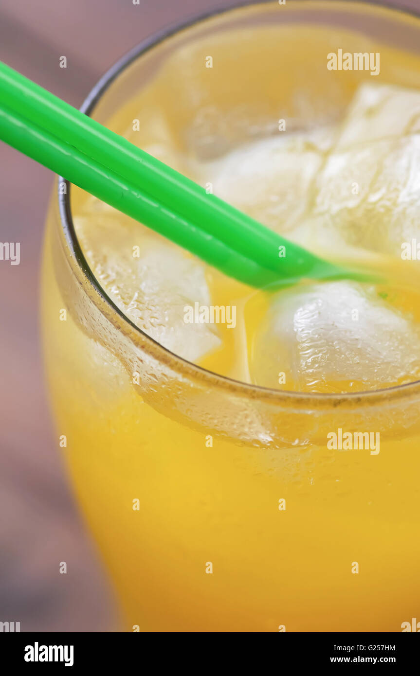 Glass of cold orange drink with straw and ice cubes Stock Photo - Alamy