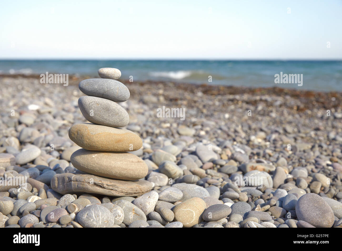 Tiny stone pyramid on a wild pebble beach Stock Photo - Alamy