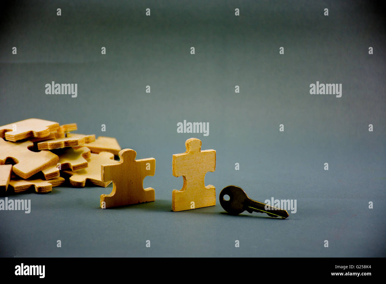 Puzzle made of wood with key.on gray background with business idea ...
