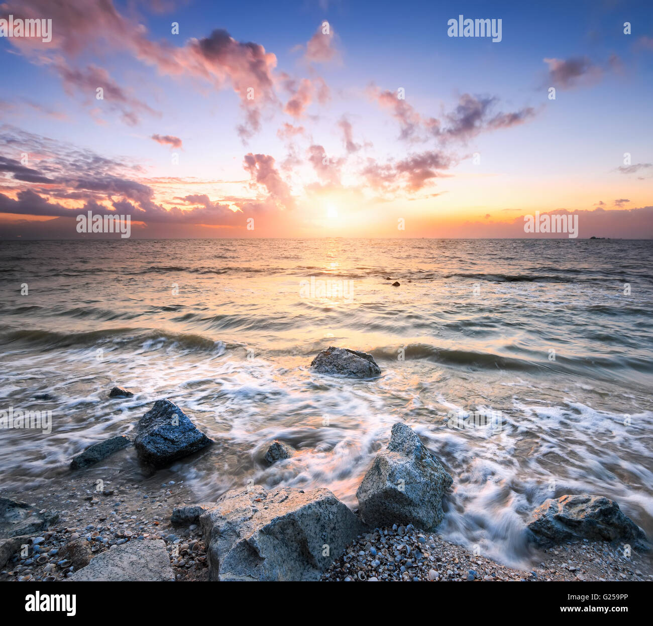 Sunset with rocks on beach hi-res stock photography and images - Alamy