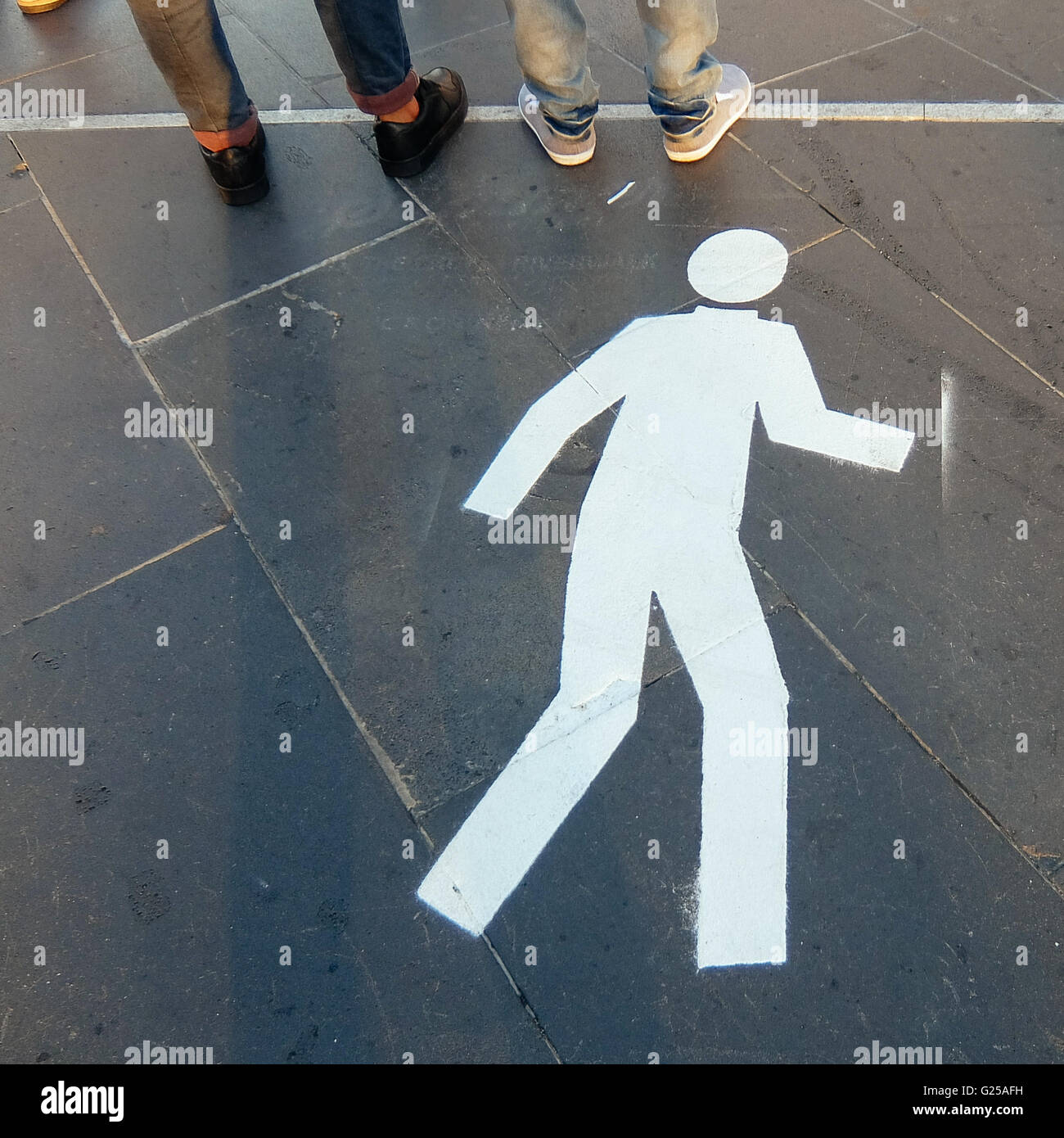 People's legs standing by pedestrian crossing sign Stock Photo - Alamy