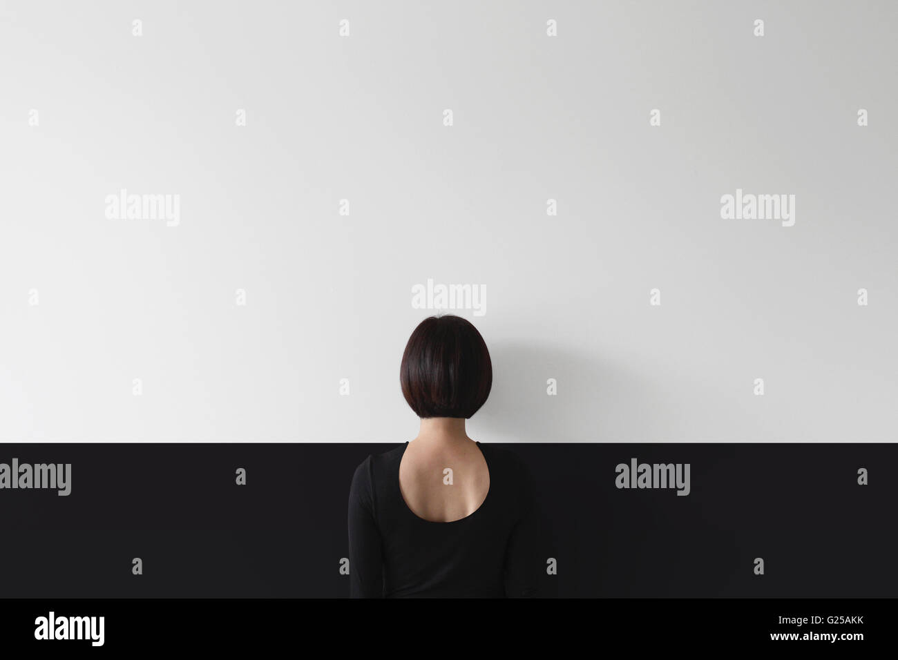 Rear view of woman standing facing wall Stock Photo - Alamy