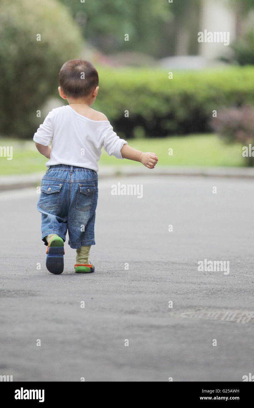 Rear view of boy walking outdoors Stock Photo - Alamy