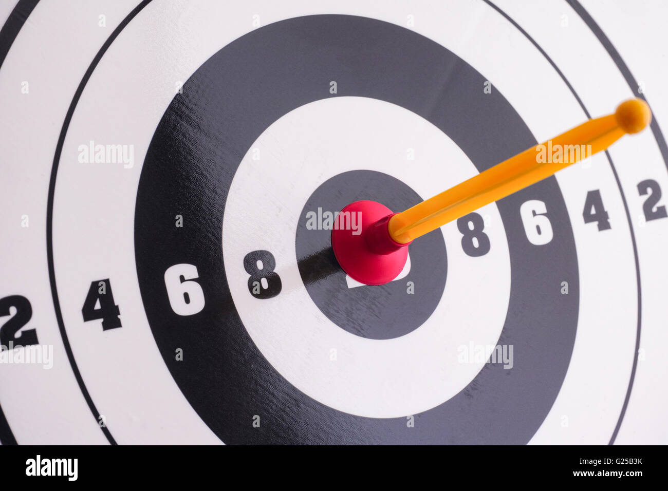 Target and arrow. Target with toy arrow in the middle Stock Photo - Alamy