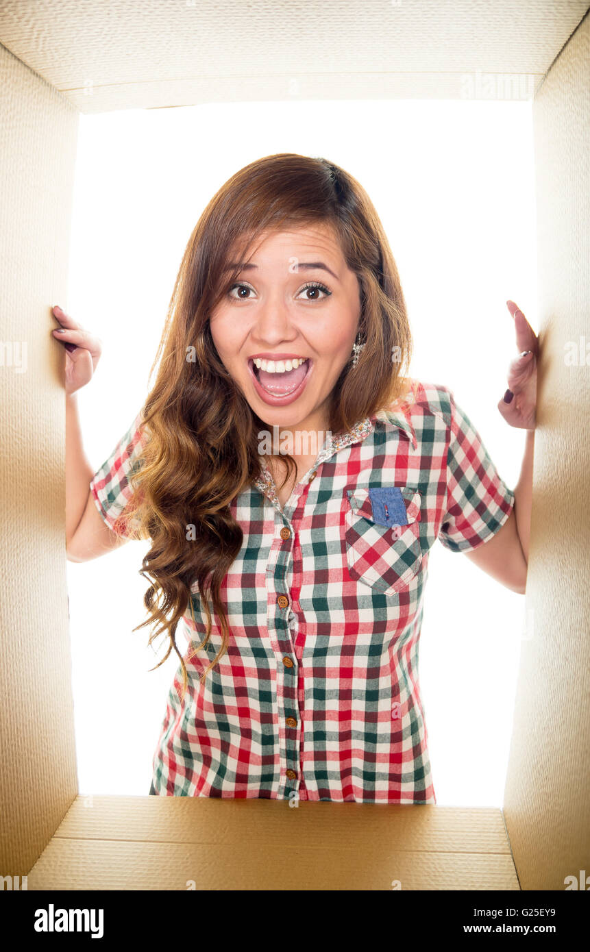 Screaming girl inside a cardboard box, two hands holding the borders in ...