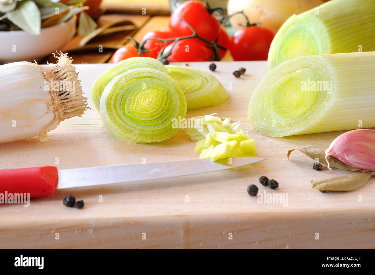Leeks cut on a cutting board on a kitchen table with vegetables ... Leeks cut on a cutting board on a kitchen table with vegetables ...