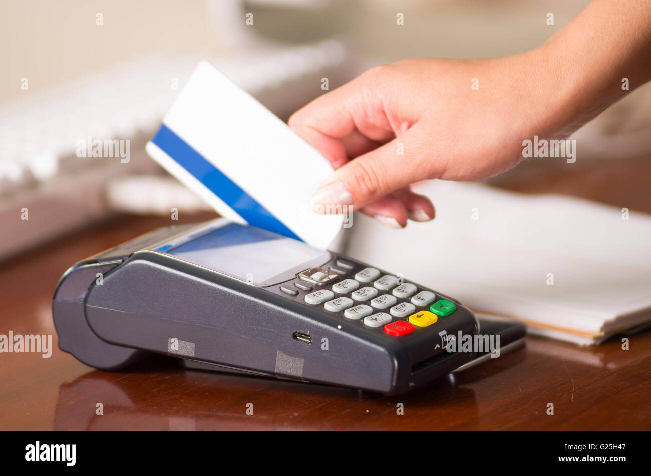 Credit card machine close up, white card with blue band swiping in the ...