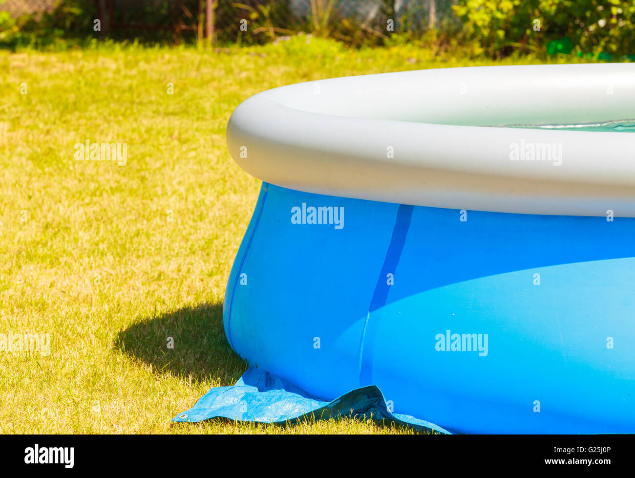 inflatable blue water pool on grass in garden Stock Photo - Alamy