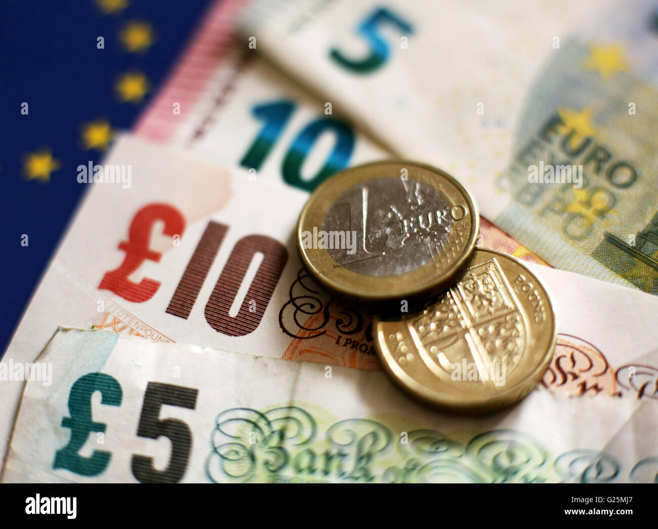 A euro coin and notes and a One Pound coin and UK banknotes, in London ...