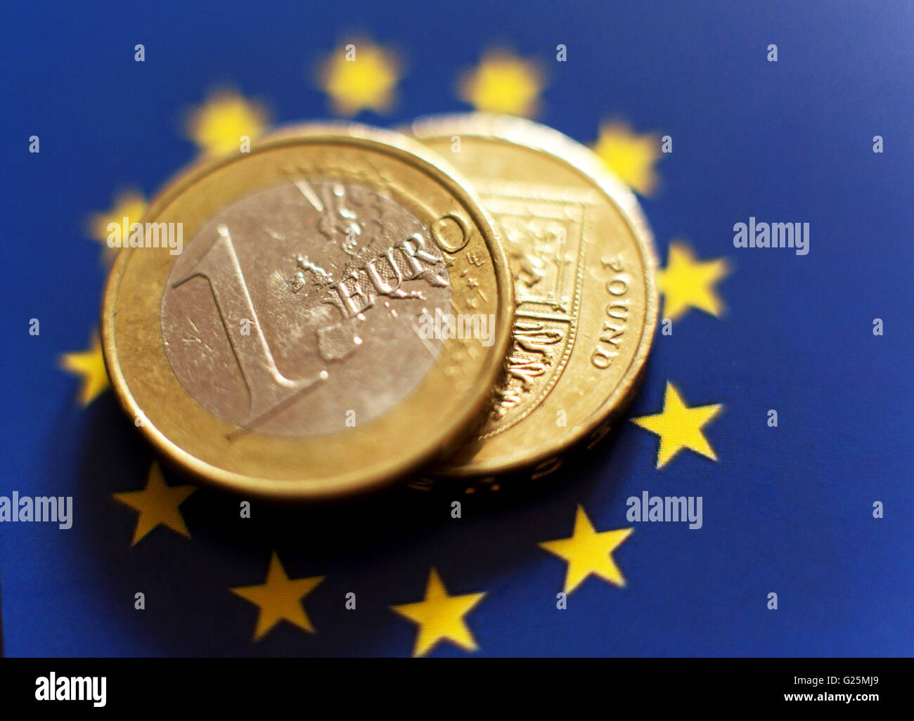 A 1 euro coin and a One Pound coin placed on a backdrop of The European ...