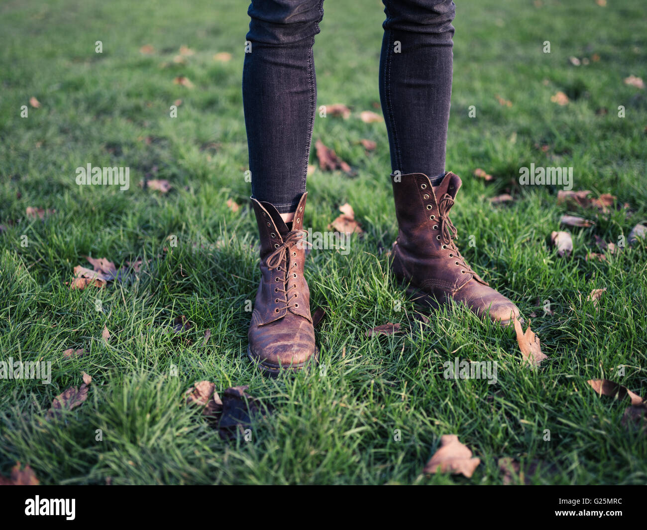 The legs of a person wearing boots and standing on the grass Stock ...