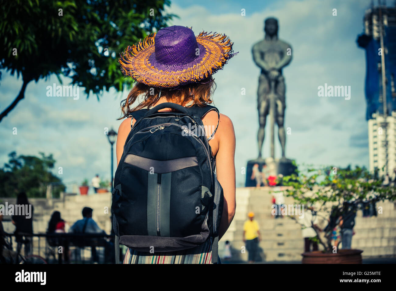 A young woman is looking at a statue in Manila Stock Photo - Alamy