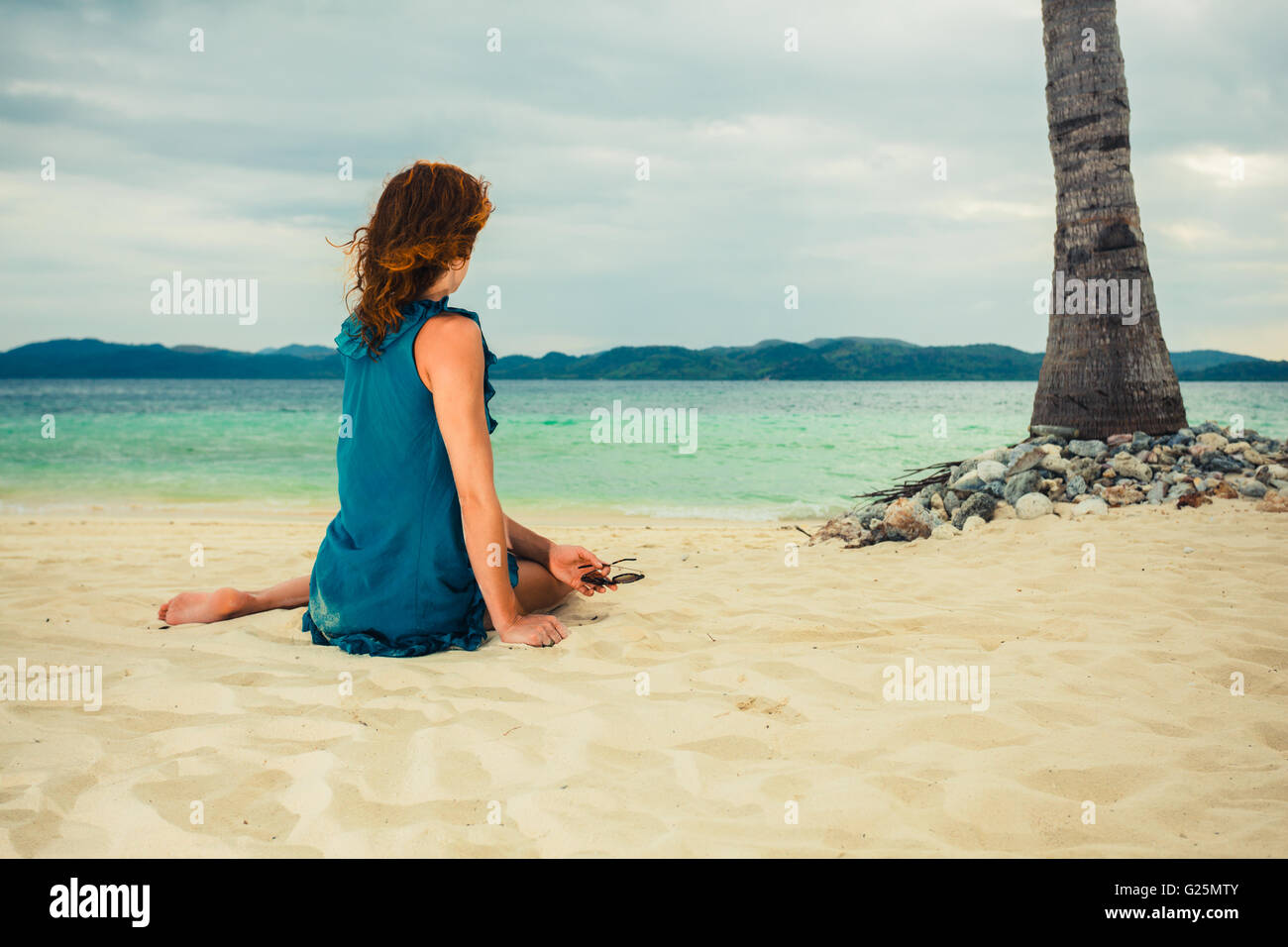 Female standing under palm tree hi-res stock photography and images - Alamy