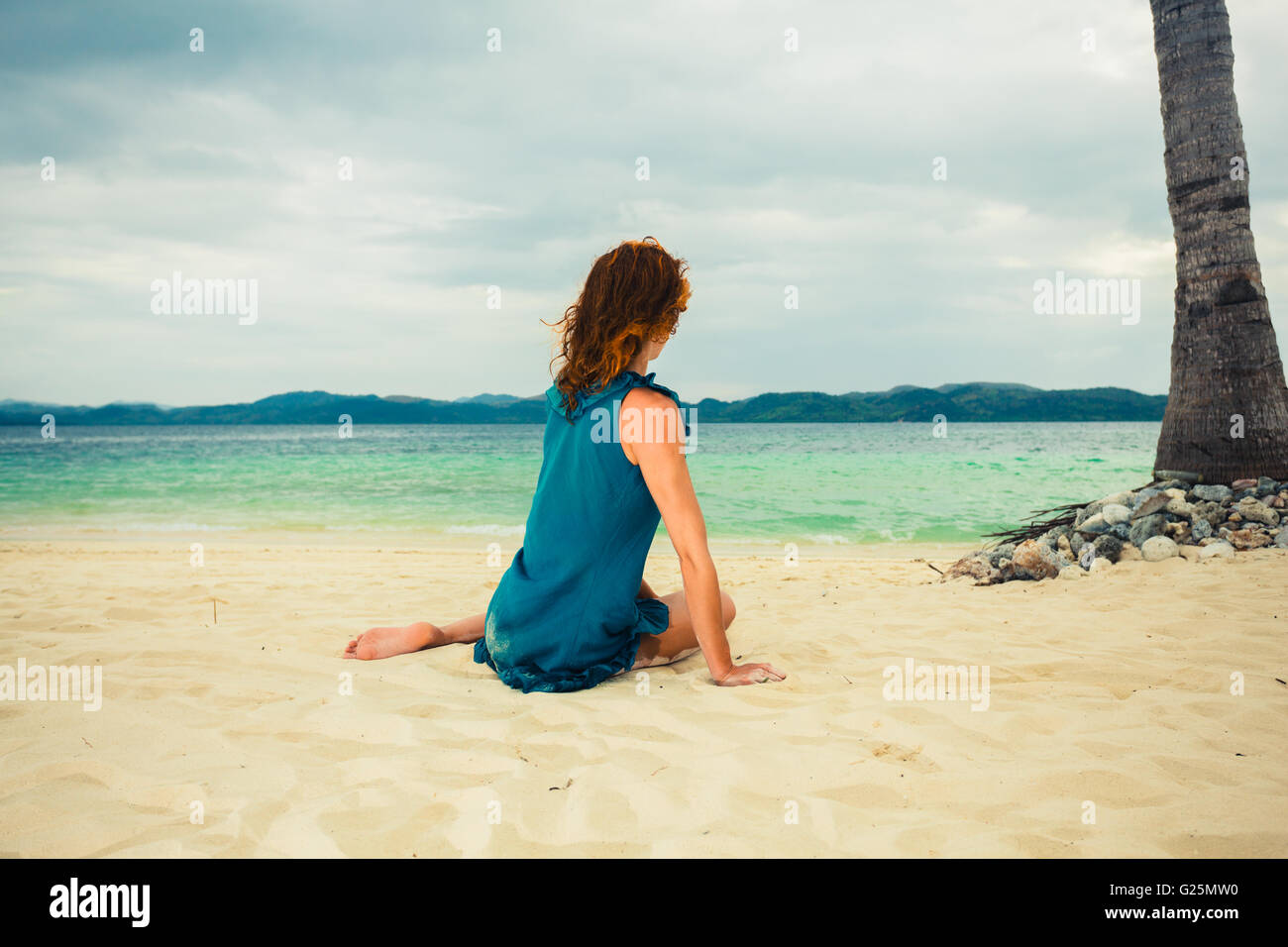 Female standing under palm tree hi-res stock photography and images - Alamy