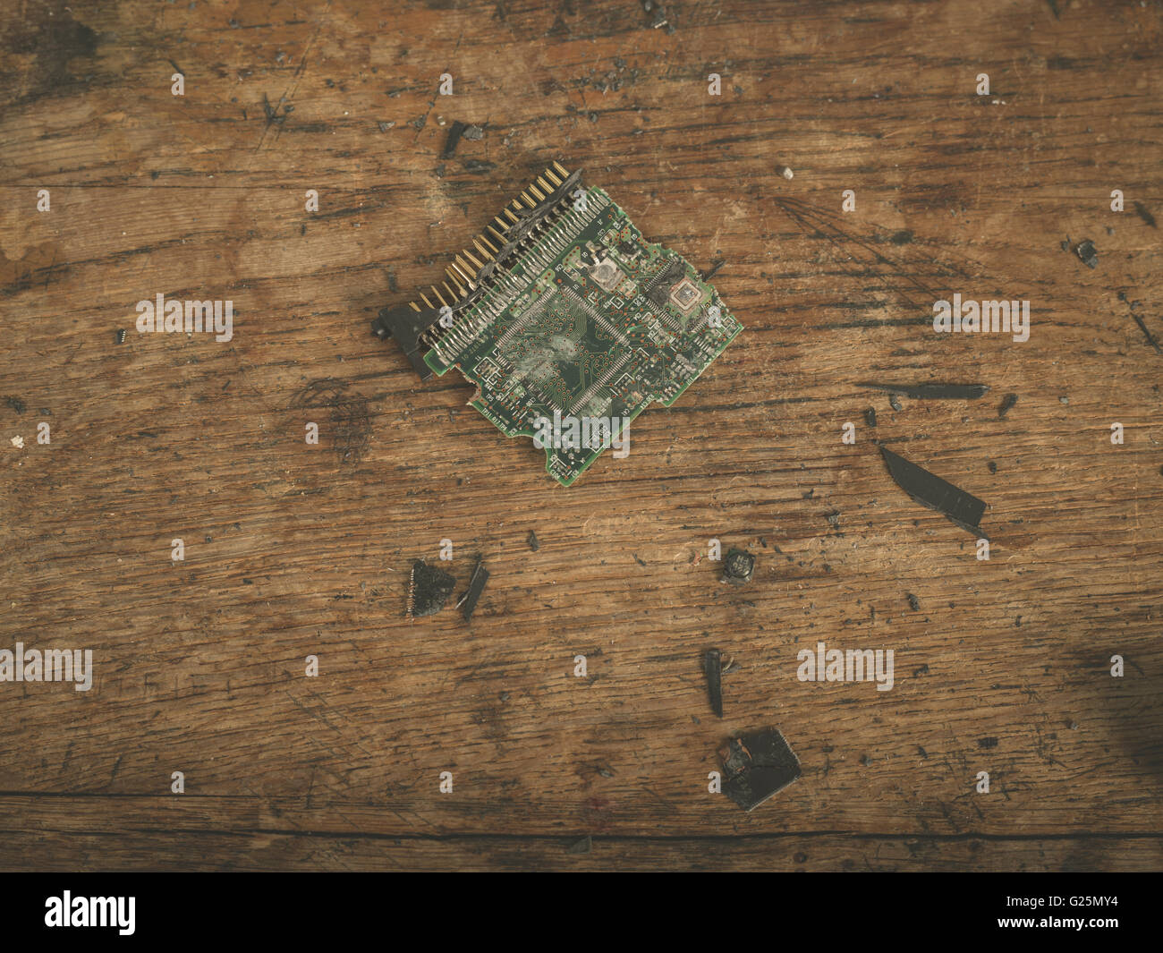 A smashed computer chip on a wooden desk Stock Photo - Alamy