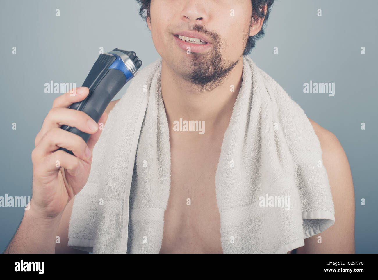 A young man cannot finish shaving because his electric razor is broken ...