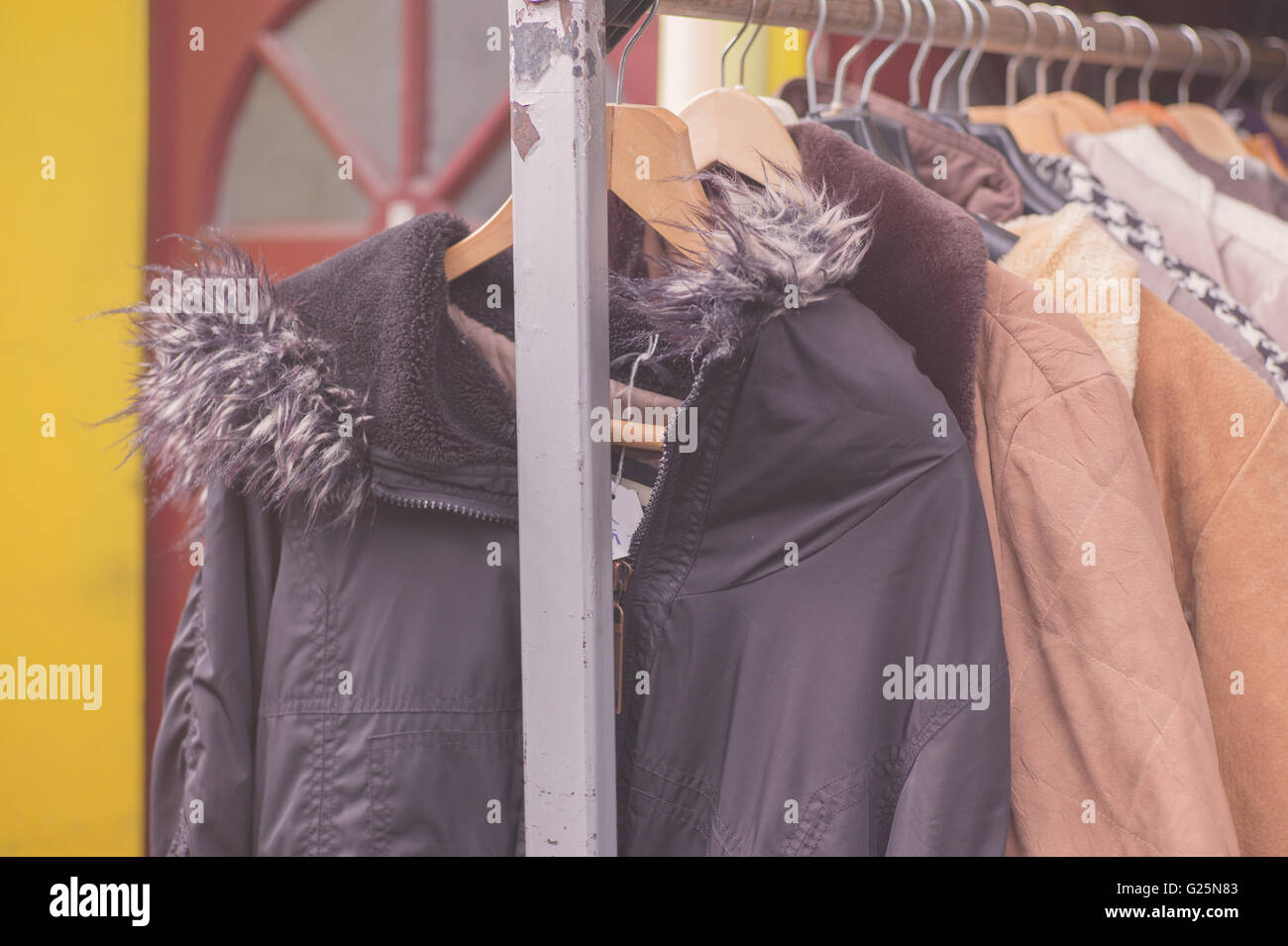 A bunch of winter jackets hanging on a rail outside Stock Photo - Alamy