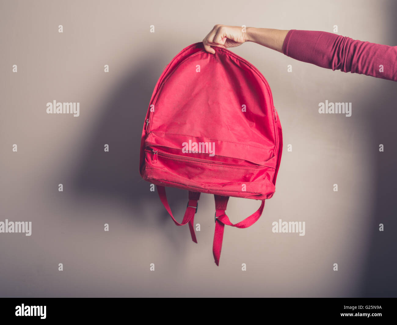 A female hand is holding a red rucksack Stock Photo - Alamy