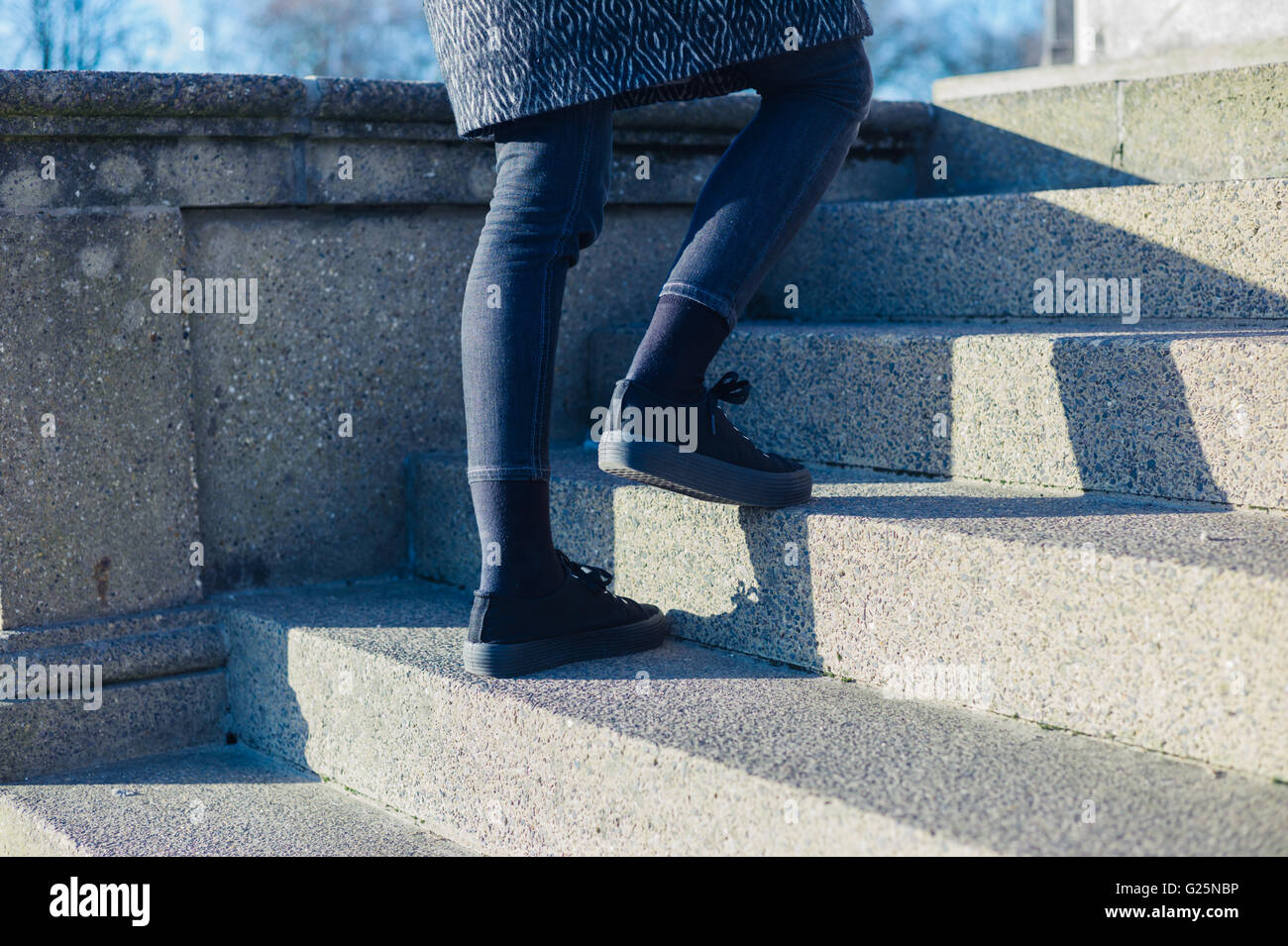 Close up on the legs of a woman as she is walking up some stairs ...