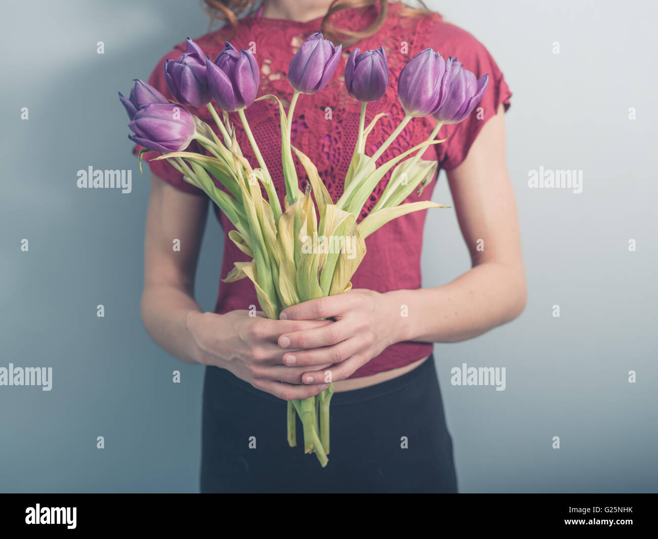 A young woman is posing with a bouquet of dead flowers Stock Photo - Alamy