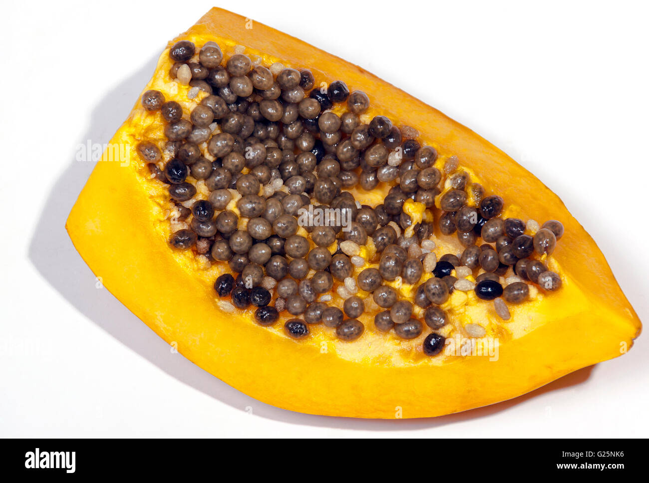 Above view of sliced section of paw paw papaya fruit and seeds on white ...
