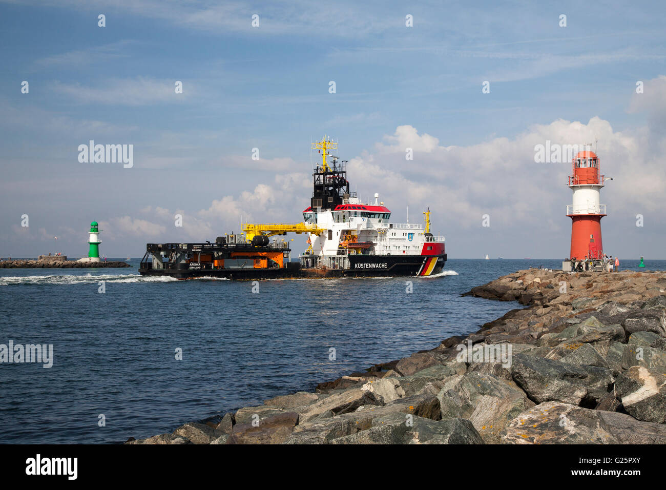 Coast Guard vessel passing two lighthouses at the harbor entrance ...