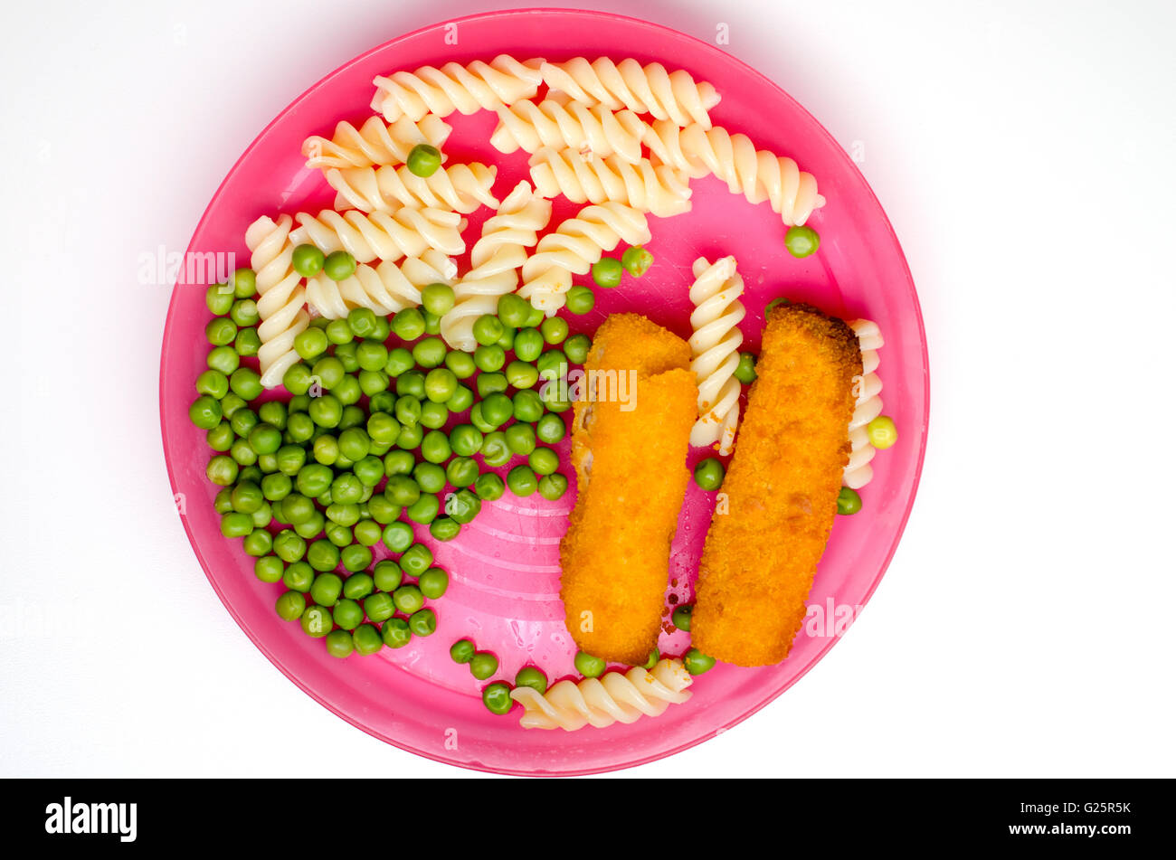 Dinner with fish fingers, pasta and peas on a childs pink plate Stock ...