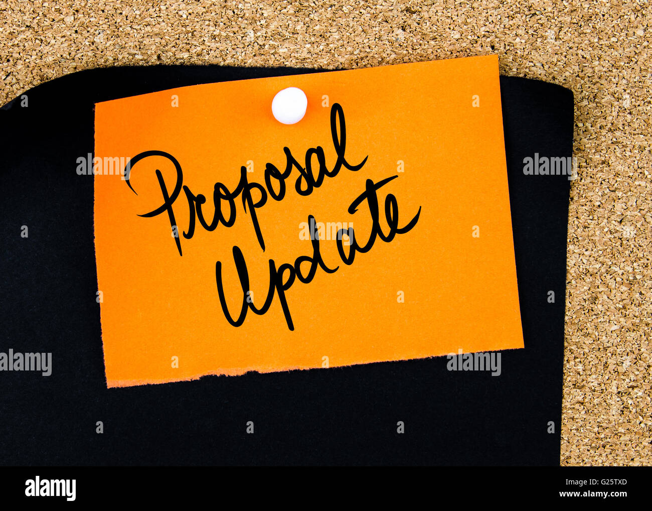 Proposal Update written on orange paper note pinned on cork board with ...