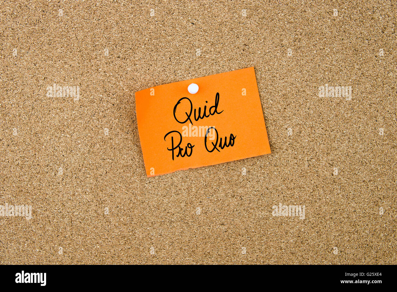 QUID PRO QUO written on orange paper note pinned on cork board with ...