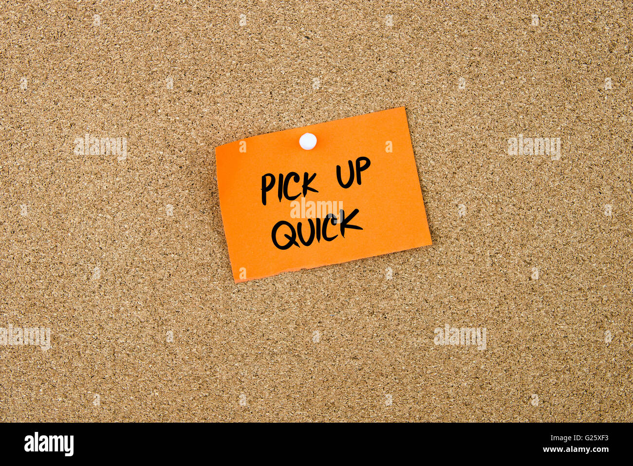 PICK UP QUICK written on orange paper note pinned on cork board with ...