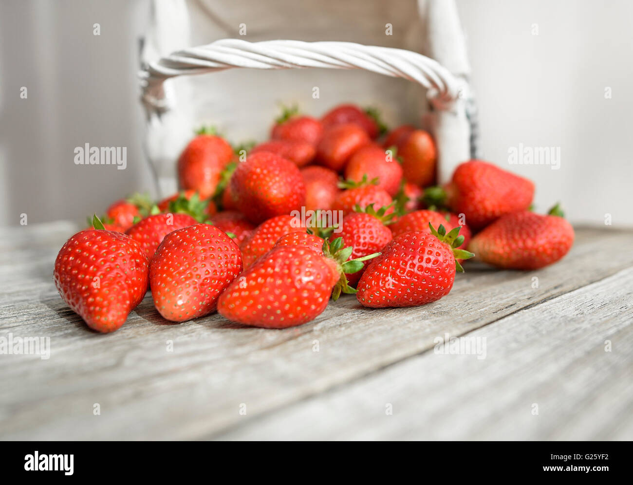 Strawberry dropped out of the basket on wooden boards Stock Photo - Alamy
